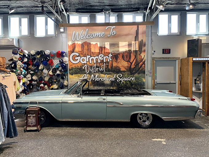 The "Garment District" sign hangs above a classic car, creating the perfect Instagram backdrop for vintage enthusiasts and automotive lovers alike.