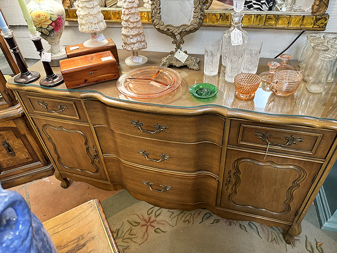 This curvy French provincial buffet isn't just furniture&mdash;it's functional sculpture topped with Depression glass that caught light in grandmother's dining room.