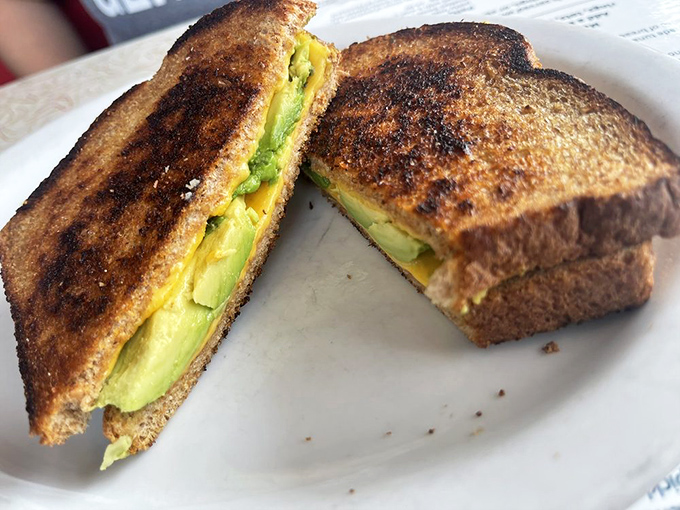 Grilled cheese gets the grown-up treatment with buttery bread achieving golden perfection while embracing creamy avocado in a warm hug.