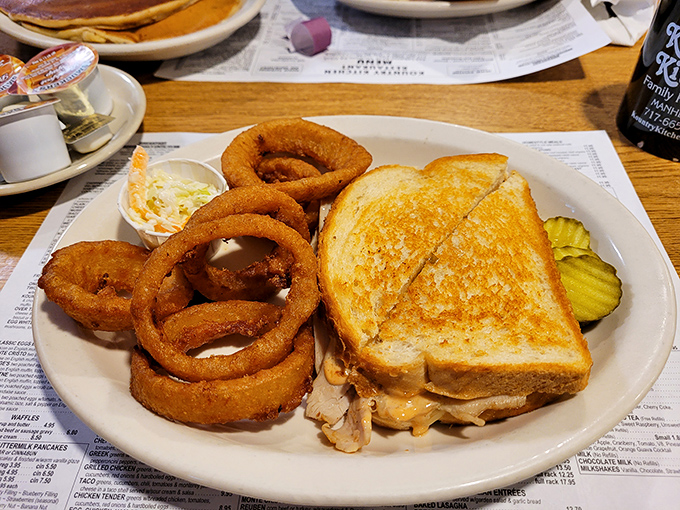 This grilled sandwich and onion ring combo isn't just lunch &ndash; it's edible architecture with a side of golden, crispy halos.