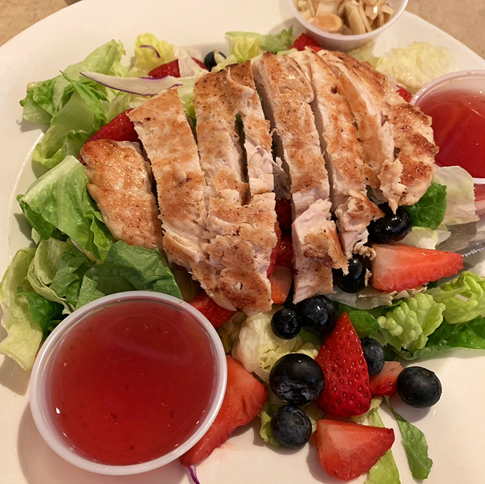 A grilled chicken salad that doesn't feel like punishment, with fresh berries and greens that might actually make you forget you're eating something healthy.