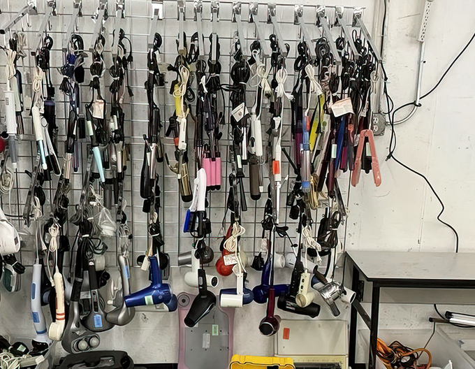 The wall of hair tools&mdash;where yesterday's styling gadgets hang like modern art, waiting for their retro revival moment.