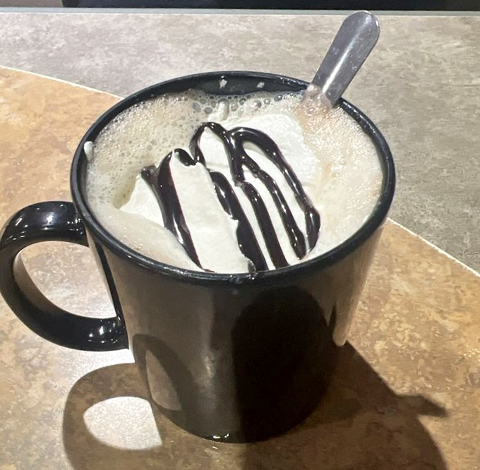 Hot chocolate topped with whipped cream and chocolate drizzle &ndash; because sometimes adults need permission to drink dessert too.