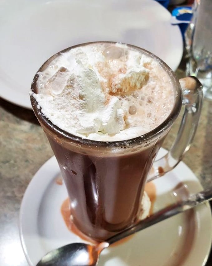 Hot chocolate elevated to an art form. That whipped cream mountain isn't just a topping&mdash;it's a statement of generosity.