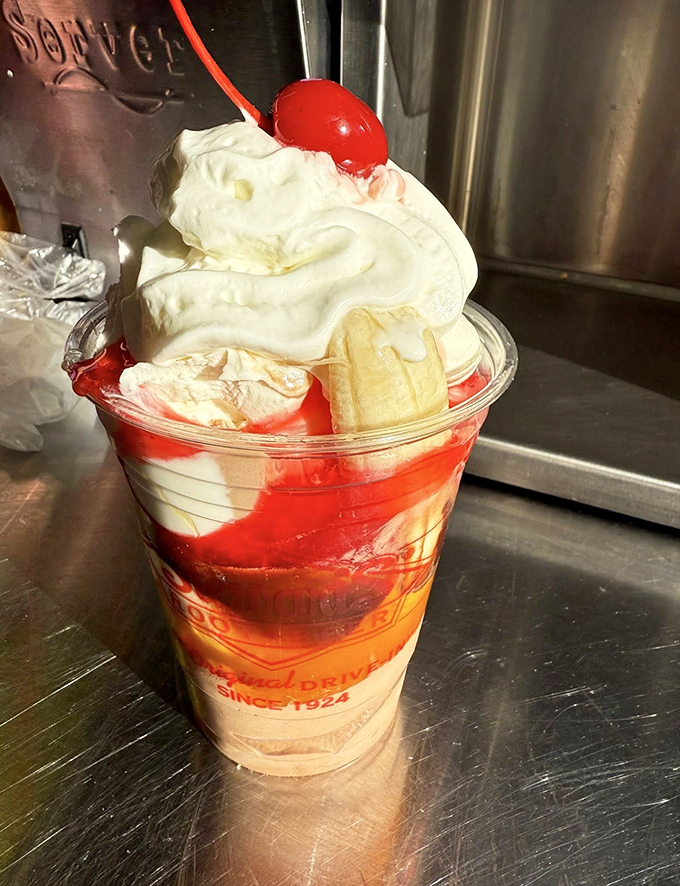 A sundae that understands the importance of proper architecture: ice cream foundation, strategic sauce rivers, and that cherry sentinel standing guard.