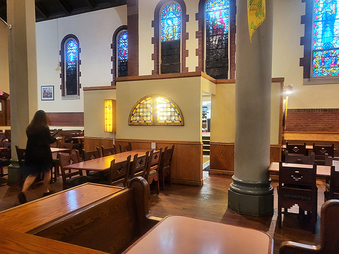 Stained glass windows cast kaleidoscope light across wooden tables where diners worship at the altar of good food.