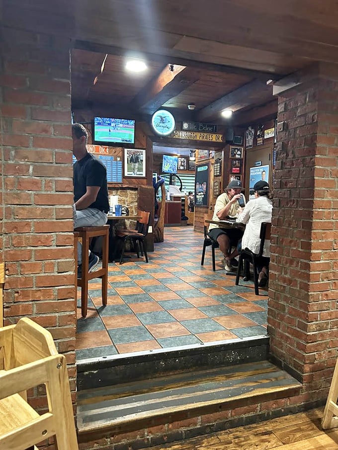 The brick archway frames a glimpse into burger paradise, where sports on TV and cold drinks create the perfect small-town pub atmosphere.