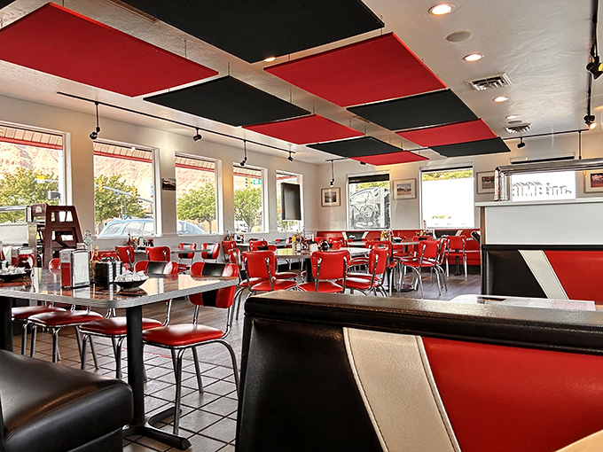 The empty dining room waits expectantly like a stage before a performance, its red chairs and classic diner aesthetic promising memorable meals to come.