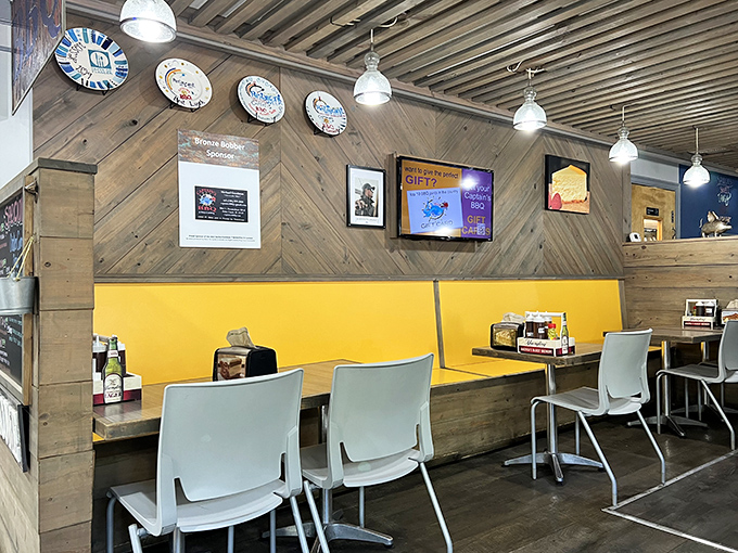 Rustic wood paneling and bright yellow booths create the perfect backdrop for the serious business of barbecue appreciation.