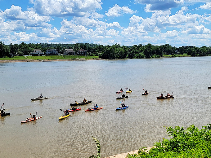 Kayakers paddle the gentle Ohio River currents, proving that sometimes the best way to see a town is from the water that built it.
