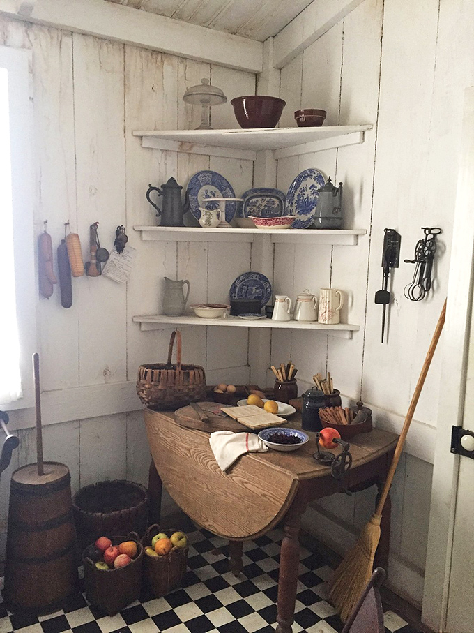 Open shelving displays blue willow china and period kitchenware in a corner that's pure 19th-century charm.