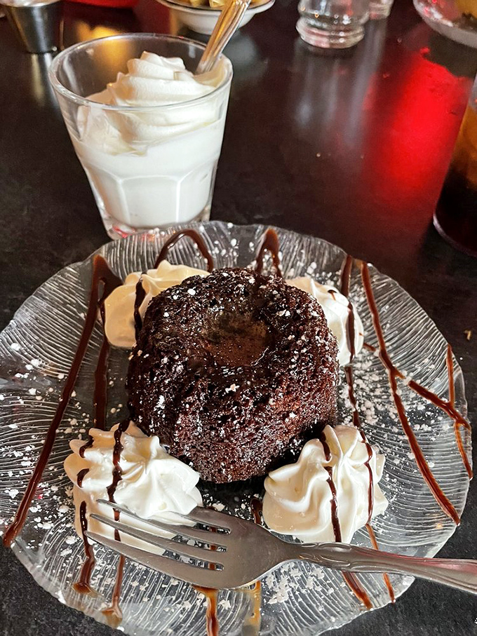 A chocolate lava cake that erupts with warm decadence. The whipped cream islands provide temporary refuge from the chocolatey magma.