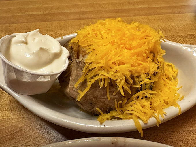 A loaded baked potato that's dressed for success &ndash; cheese melting like a sunset over fluffy potato mountains.
