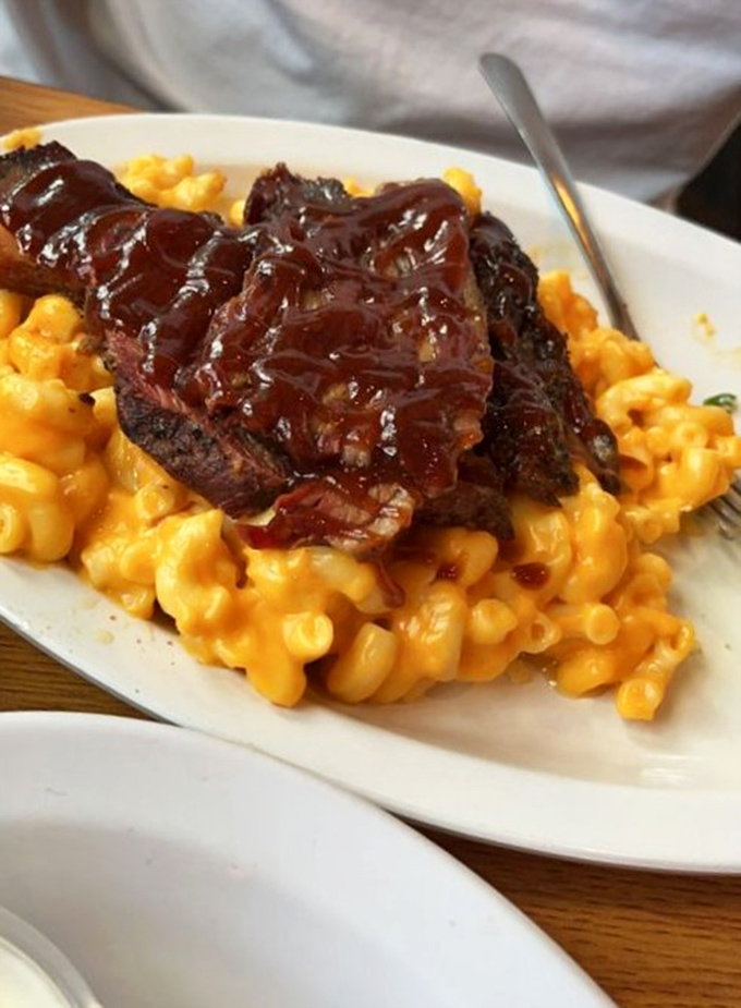 Barbecued meat lounging on a bed of mac and cheese like it's on vacation at a cheesy resort. This is what dreams are made of.