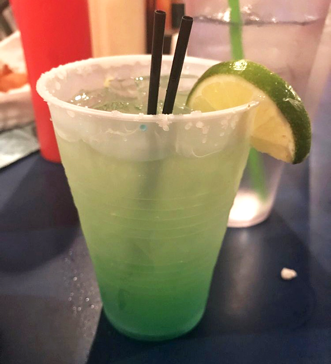 This electric blue margarita isn't just a drink &ndash; it's a vacation in a plastic cup. One sip and you're mentally collecting seashells on some distant shore.