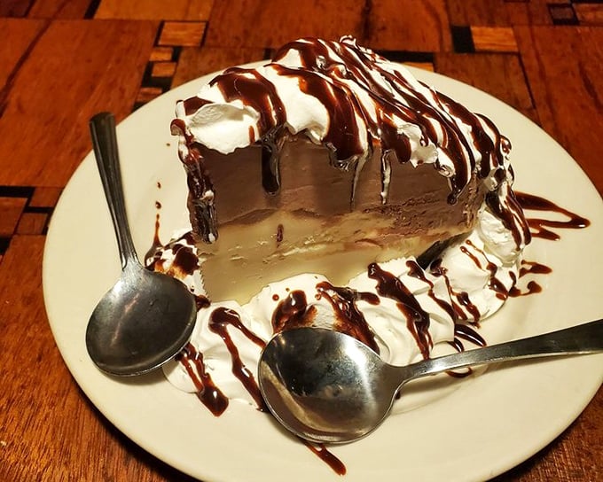 This isn't just mud pie—it's a chocolate skyscraper with whipped cream clouds and chocolate sauce rain that makes you forget you're supposed to be saving room for dinner.