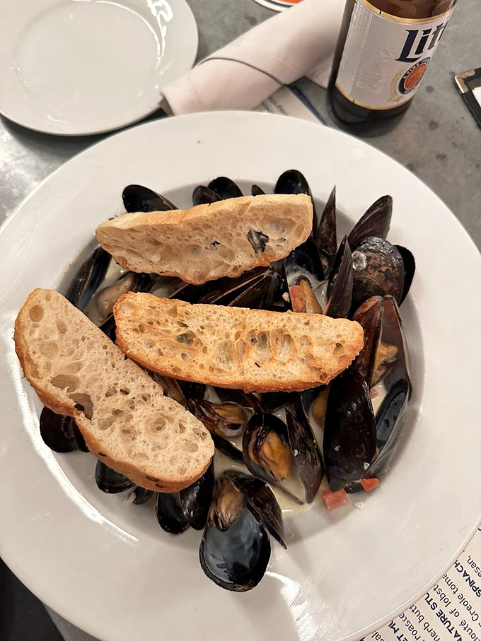 Mussels that have clearly been living their best life before arriving at your table, accompanied by crusty bread perfect for sauce-sopping operations.
