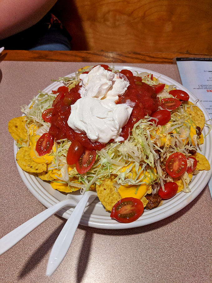 These nachos aren't messing around &ndash; loaded with cheese, fresh tomatoes, and generous dollops of sour cream and salsa. Sharing is technically optional but strongly advised.
