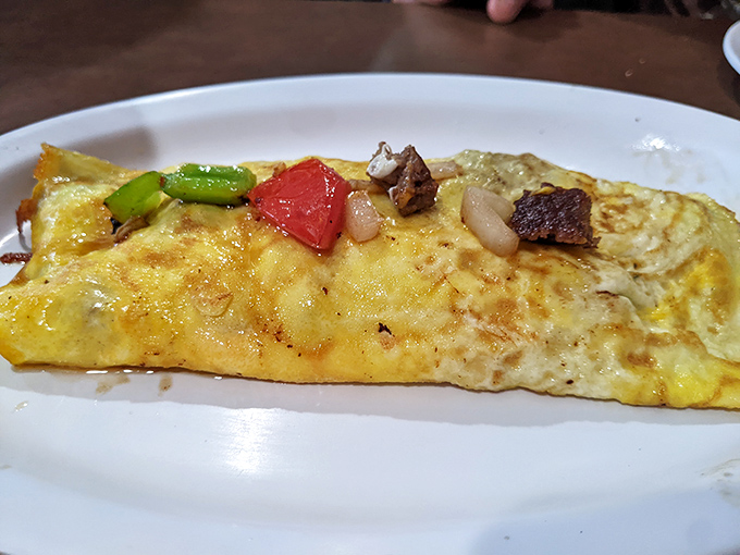 An omelet loaded with vegetables proves that even hearty mountain breakfasts can sneak in some nutritional redemption for your conscience.