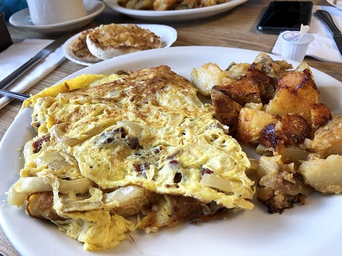 An omelet that clearly didn't skip gym day—plump with fillings and flanked by golden home fries that deserve their own fan club.