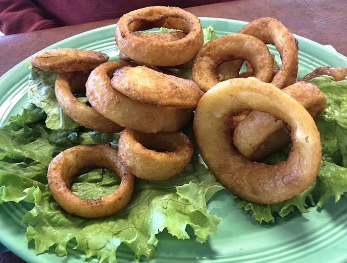 Onion rings stacked like golden halos, crispy enough to make angels weep and served on the kind of green plate grandma saved for company.