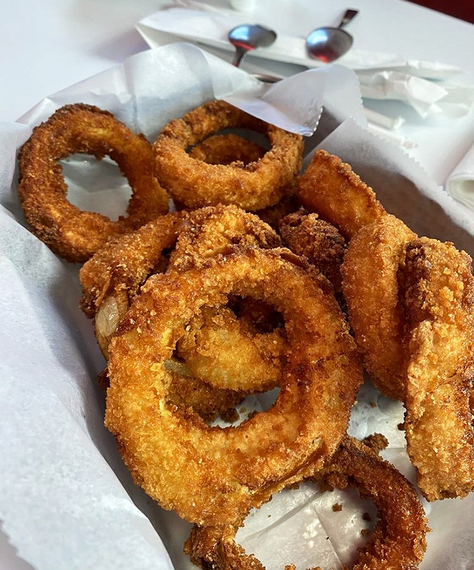 These onion rings aren't just fried, they're transformed—golden halos of crispy perfection that make you temporarily forget vegetables are supposed to be healthy.