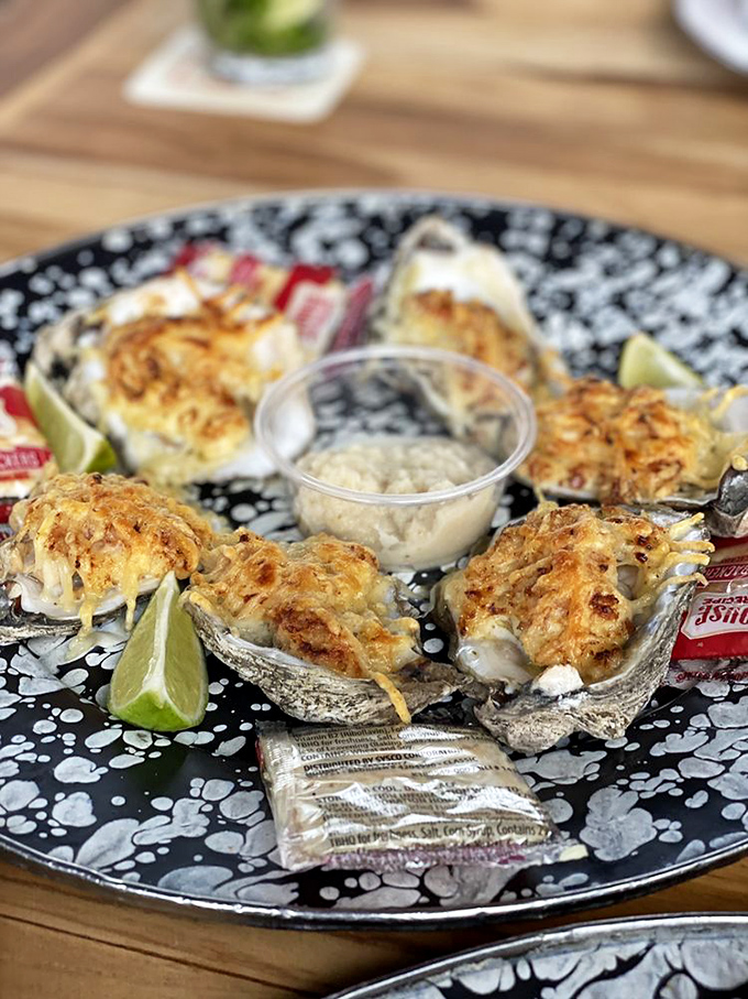Oysters Rockefeller looking like they dressed up for a fancy party, topped with cheesy goodness and waiting for their lime squeeze.