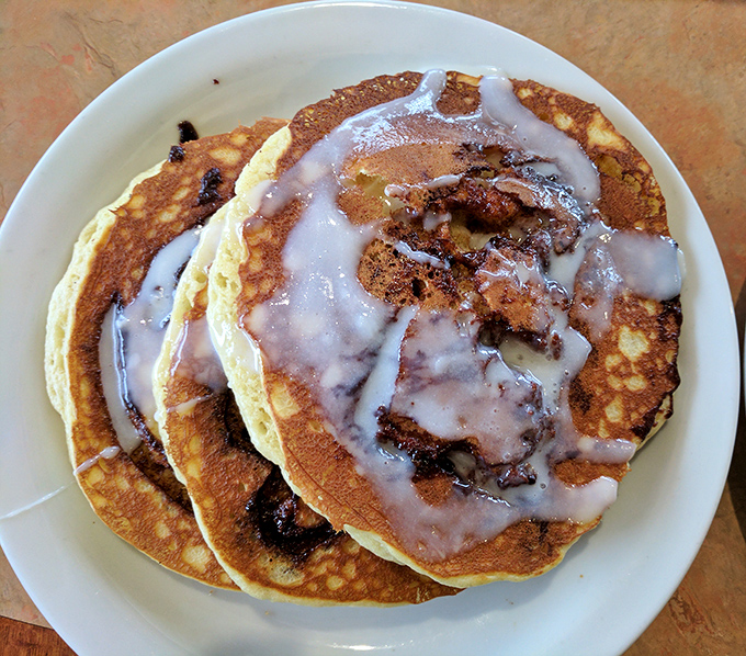 Pancakes so fluffy they practically hover above the plate, with cinnamon swirls that hypnotize you into ordering seconds.