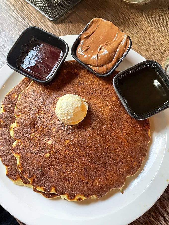 These pancakes arrive with three sidekicks&mdash;chocolate, peanut butter, and maple syrup&mdash;forming a breakfast dream team.