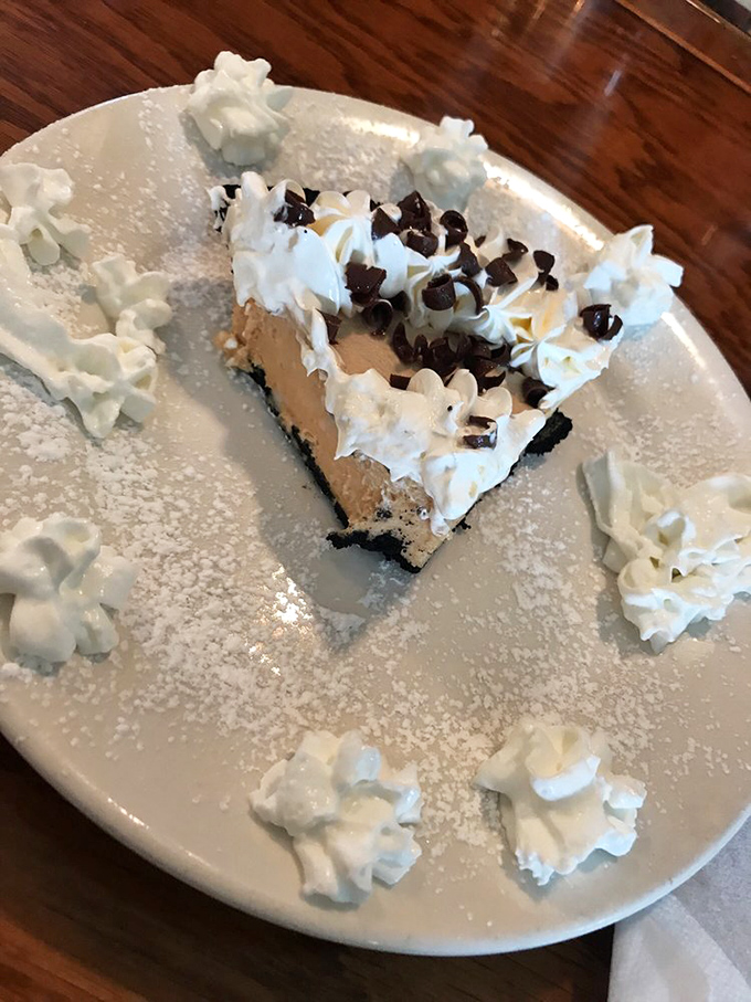 Peanut butter cream pie surrounded by whipped cream dollops – dessert architecture that would make Frank Lloyd Wright put down his blueprint and pick up a fork.