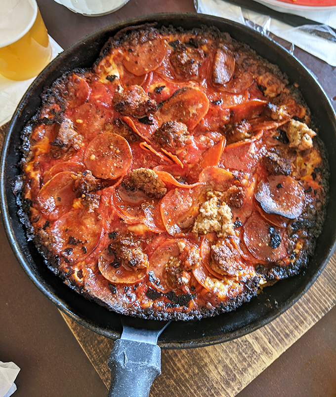 The pepperoni and sausage pan pizza isn't just food&mdash;it's a religious experience with a congregation of toppings nestled in that signature charred crust.