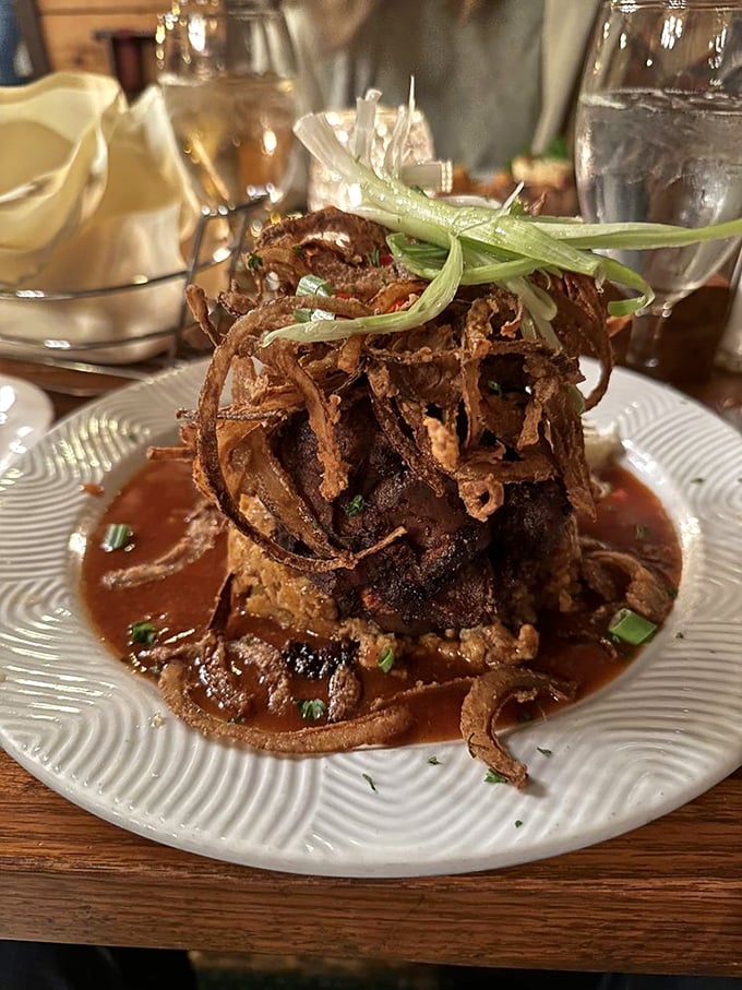 This pork shank isn't just dinner; it's a medieval feast centerpiece, complete with a moat of savory sauce and crispy onion battlements.