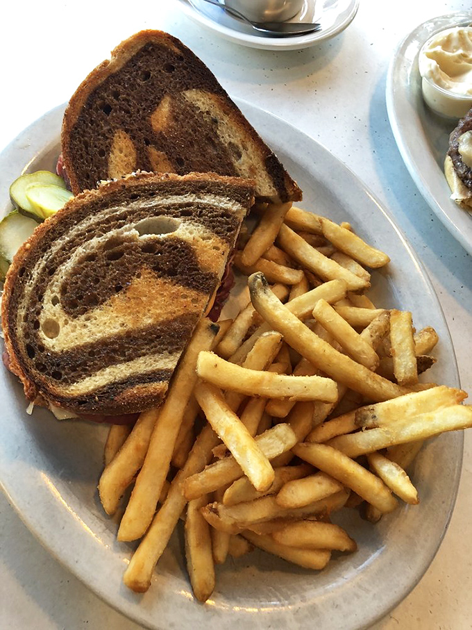 The Reuben that requires both hands and several napkins. Marbled rye, tangy sauerkraut, and fries crisp enough to make a potato proud.