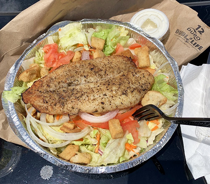 Who needs fancy plating when you've got a perfectly broiled fish fillet holding court atop a fresh garden salad?