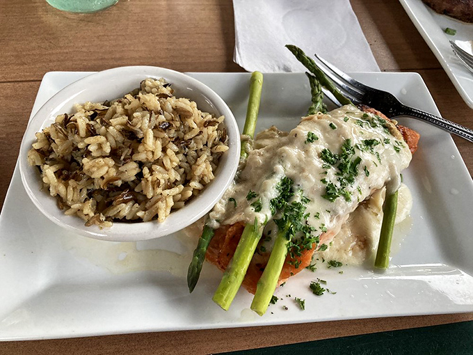 Salmon Oscar living its best life with asparagus spears and creamy sauce. The wild rice side dish is no slouch either.
