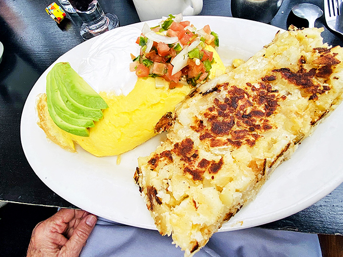 An omelet so perfectly executed it deserves its own star on the Hollywood Walk of Fame, flanked by fluffy eggs and fresh avocado.