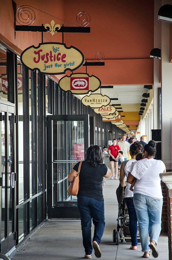 Decorative fleur-de-lis signs mark the covered walkway, where Louisiana shoppers strategize their next retail conquest between stores.
