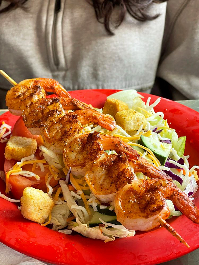Grilled shrimp skewer perched atop a colorful salad&mdash;proof that healthy eating doesn't have to be punishment. Those char marks tell the real story.