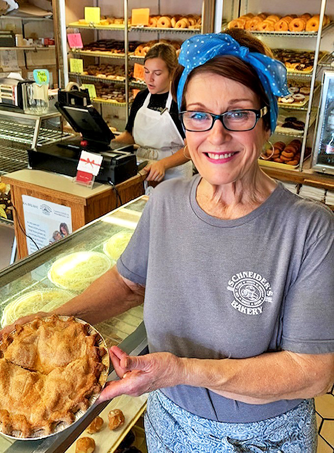 The bakery staff presents a freshly-baked pie with the pride of an artist unveiling a masterpiece. That smile says, "Yes, it tastes even better than it looks."