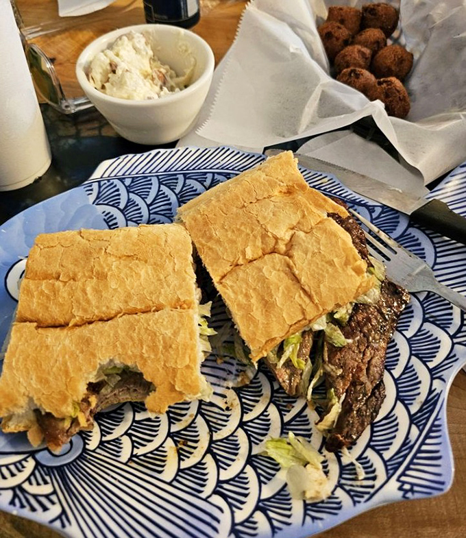A proper steak po-boy served on blue-patterned plates &ndash; because sometimes the best steakhouse experience comes between two pieces of bread.