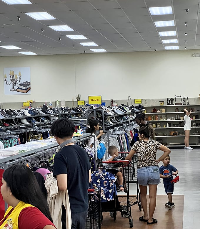 Families navigate the aisles with red shopping carts, teaching the next generation the thrill of the thrift store treasure hunt.