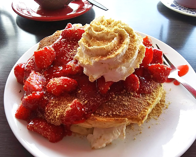 Strawberry shortcake and pancakes had a delicious love child. That mountain of whipped cream deserves its own climbing expedition permit.