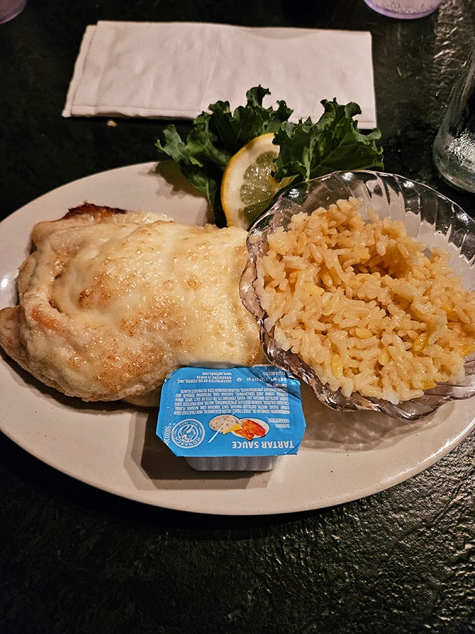 Cheese-topped seafood paired with perfectly cooked rice pilaf. The lemon wedge isn't just garnish&mdash;it's the bright note that ties this symphony together. 