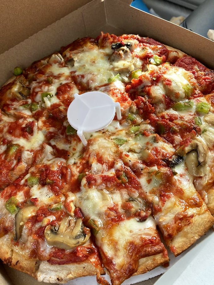 The supreme pizza arrives loaded with toppings that somehow achieve perfect balance instead of chaotic excess.