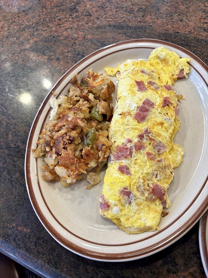 This isn't just an omelet&mdash;it's a morning masterpiece where ham cubes play hide-and-seek in a fluffy yellow landscape of perfectly cooked eggs.