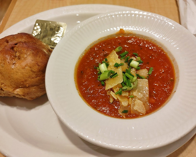 A bowl of tomato basil soup that glows like a Minnesota sunset, accompanied by a Nova Scotia roll that's begging to be dunked.