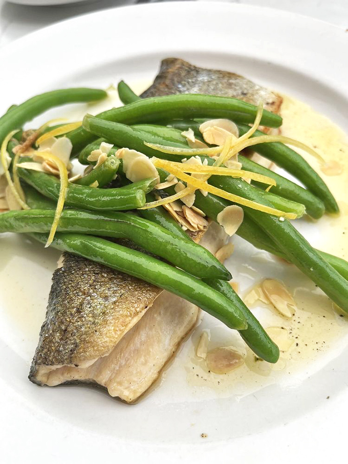 Trout amandine that's swimming in buttery goodness. Those green beans aren't just a garnish—they're diving into the best sauce bath of their lives.