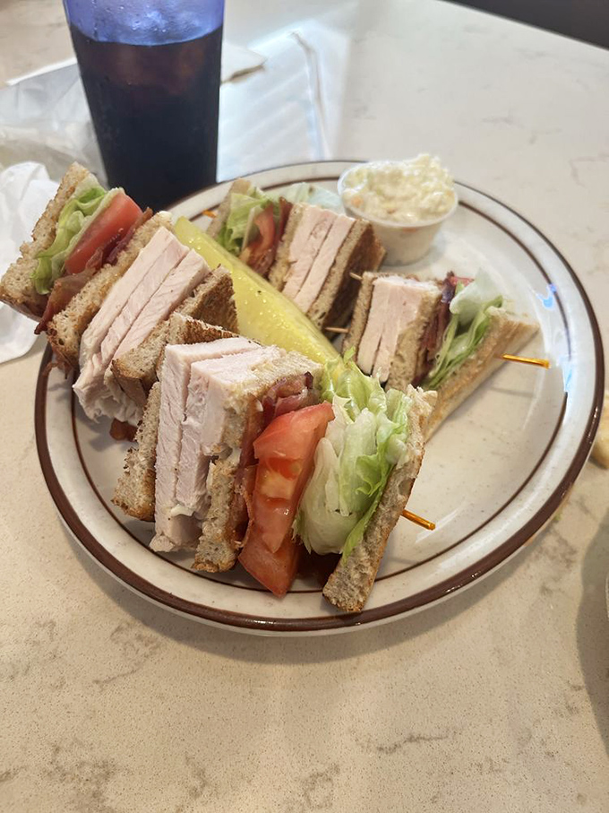 The turkey club sandwich&mdash;architecture you can eat. Precisely stacked layers create the skyscraper of sandwiches, held together with toothpick engineering.