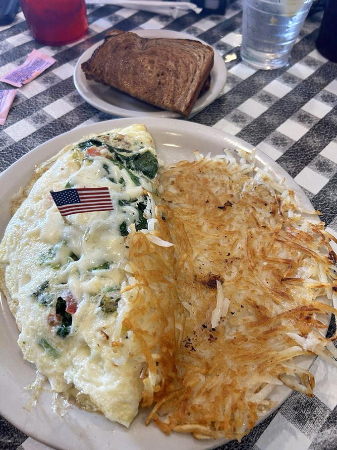 An omelet that's eating its vegetables and looking spectacular doing it. Those hash browns are the crispy supporting actors who steal every scene.
