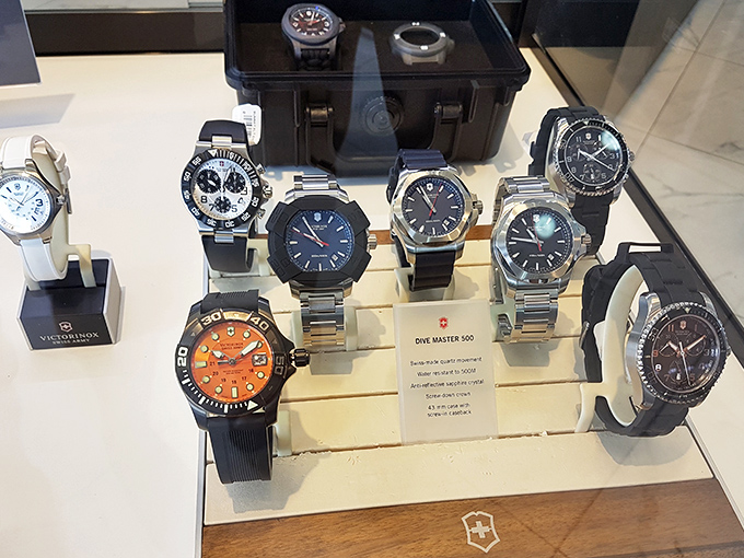 Victorinox watches gleam under display lights, offering Swiss precision timekeeping for those who've lost track of shopping hours.